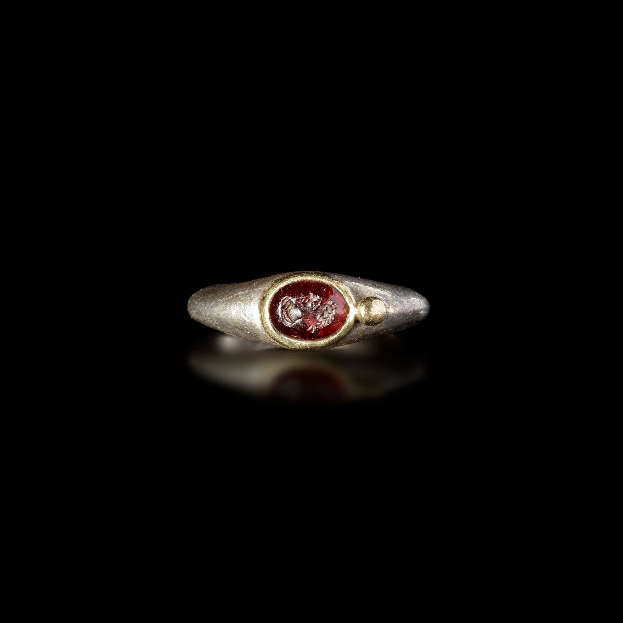 A SILVER ROMAN RING WITH A GOLD MOUNT HOLDING A GARNET INTAGLIO, 3RD ...