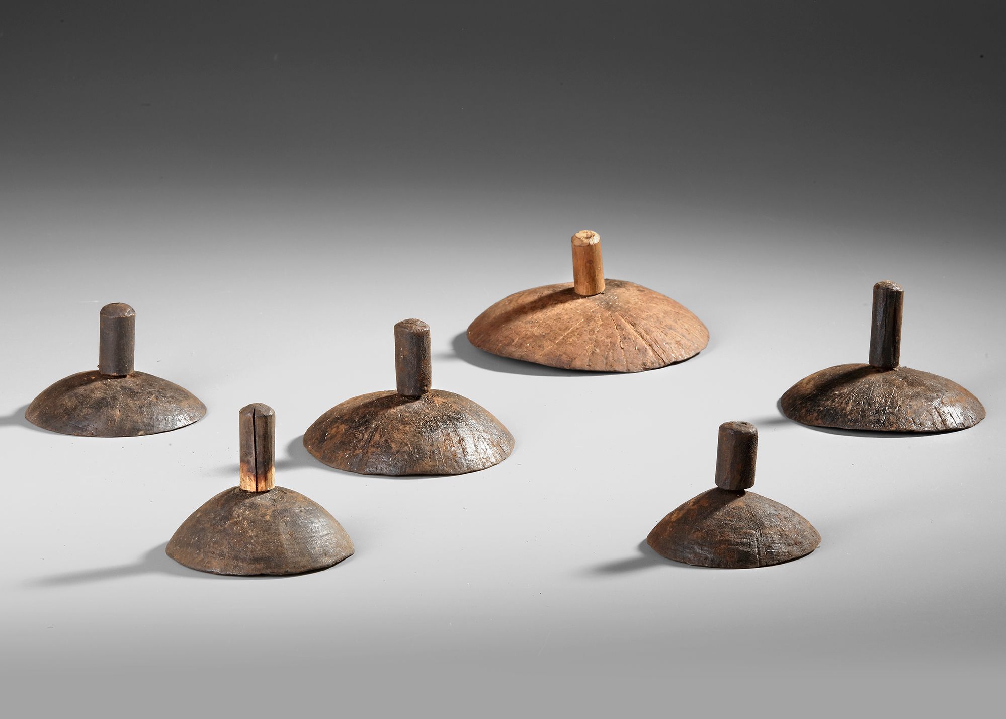 Six old and well used Anelam spinning tops. Ceremonial toys.